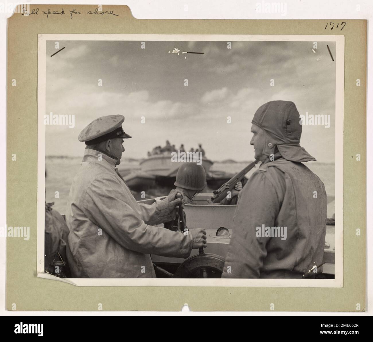 A Coast Guard officer and coxswain pilot a landing barge during ...