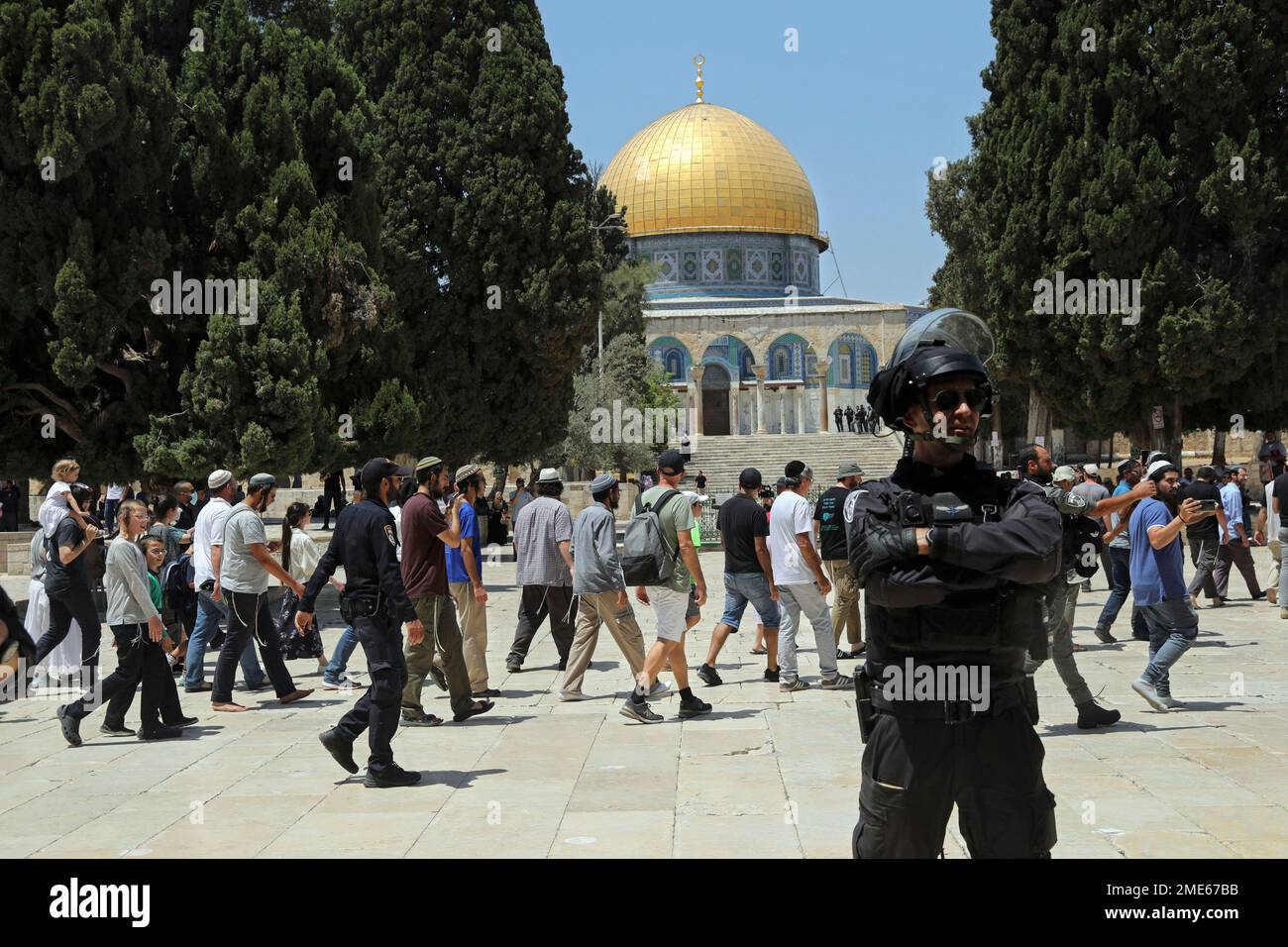 An Israeli police officer stands guard as Jewish men visit the Dome of ...
