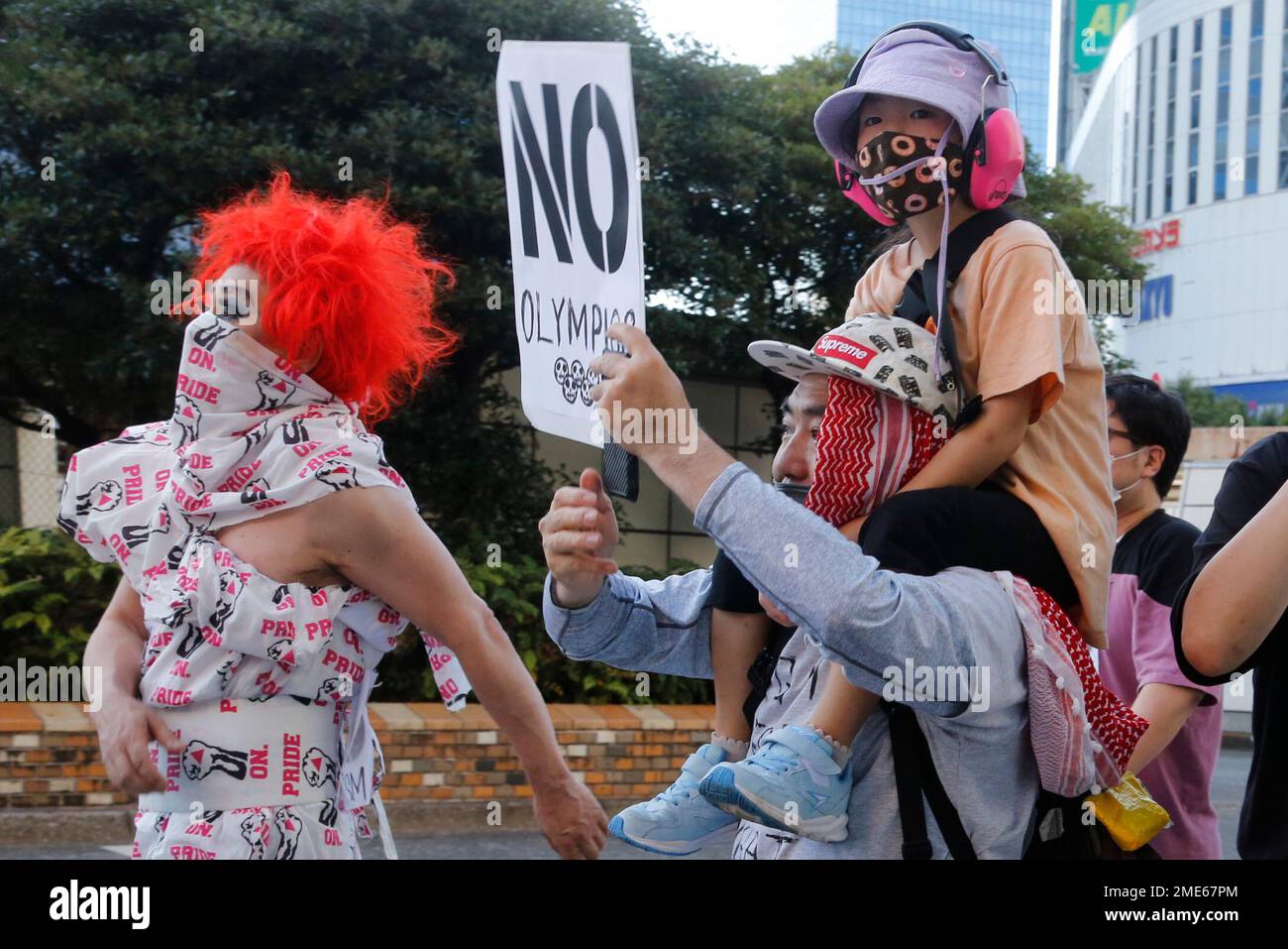 People march in Tokyo's Shinjuku shopping district Sunday, July 18 ...