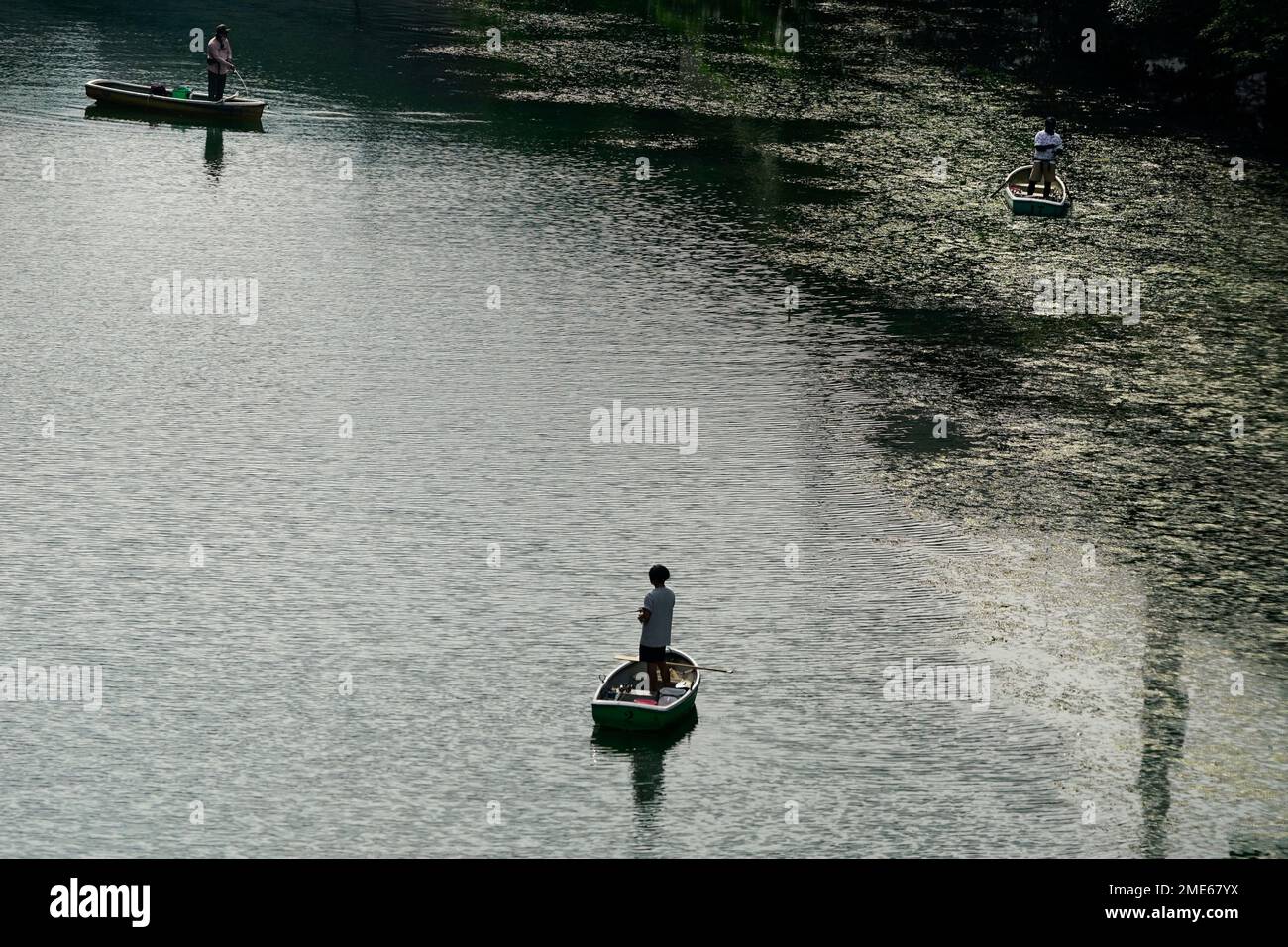 People fish in a moat ahead of the 2020 Summer Olympics on Thursday ...