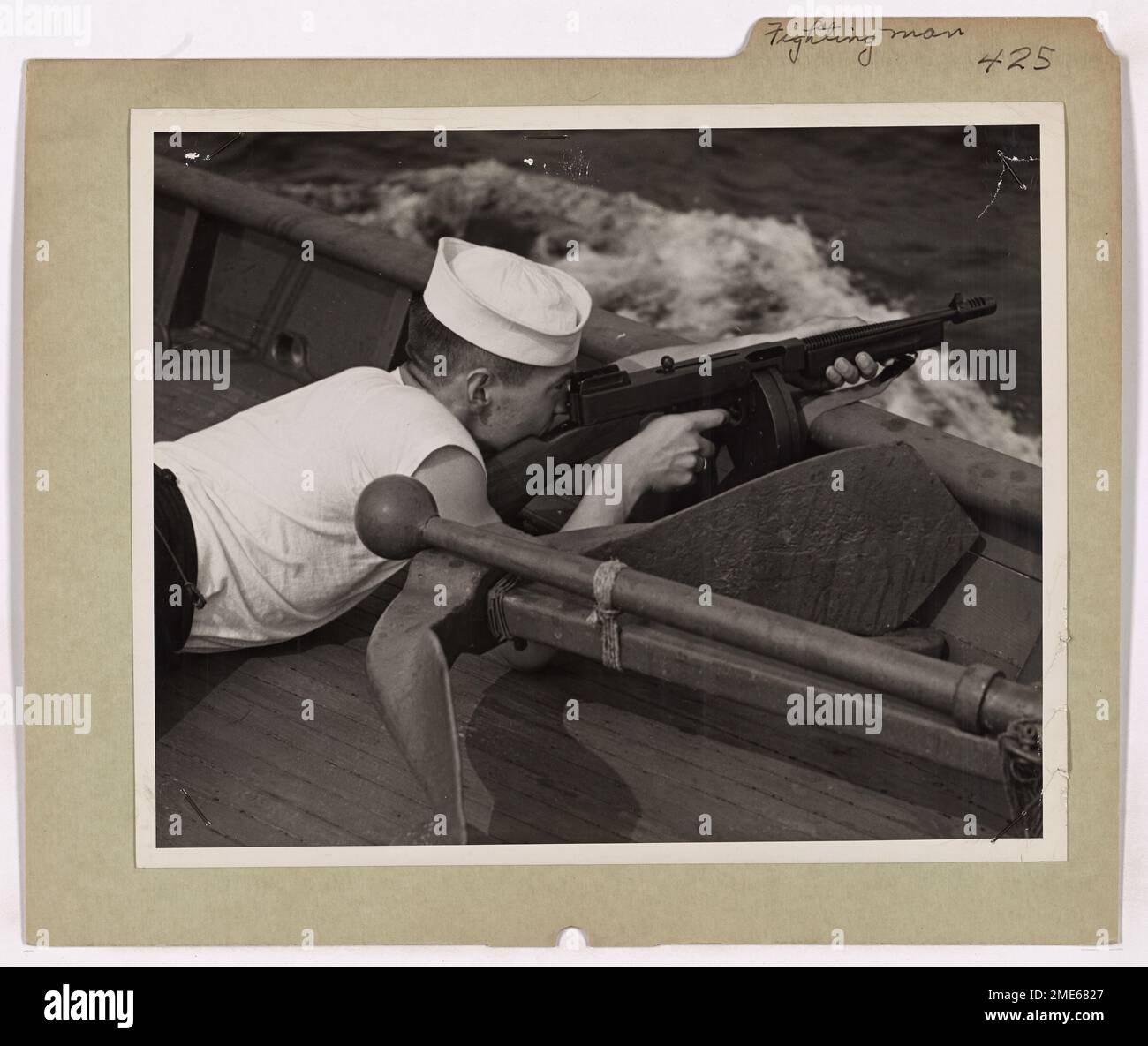 This image portrays a Coast Guardsman pointing his gun towards an ...