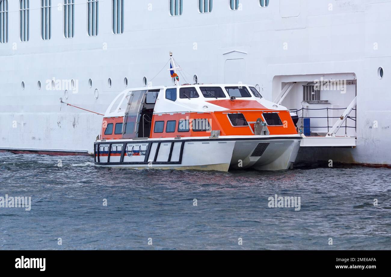 small passenger boat next to large ferry Stock Photo - Alamy