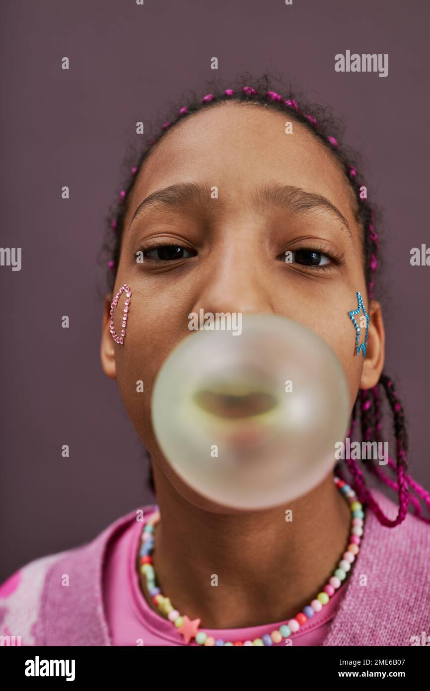 Vertical fisheye portrait of black teenage girl blowing bubblegum ...