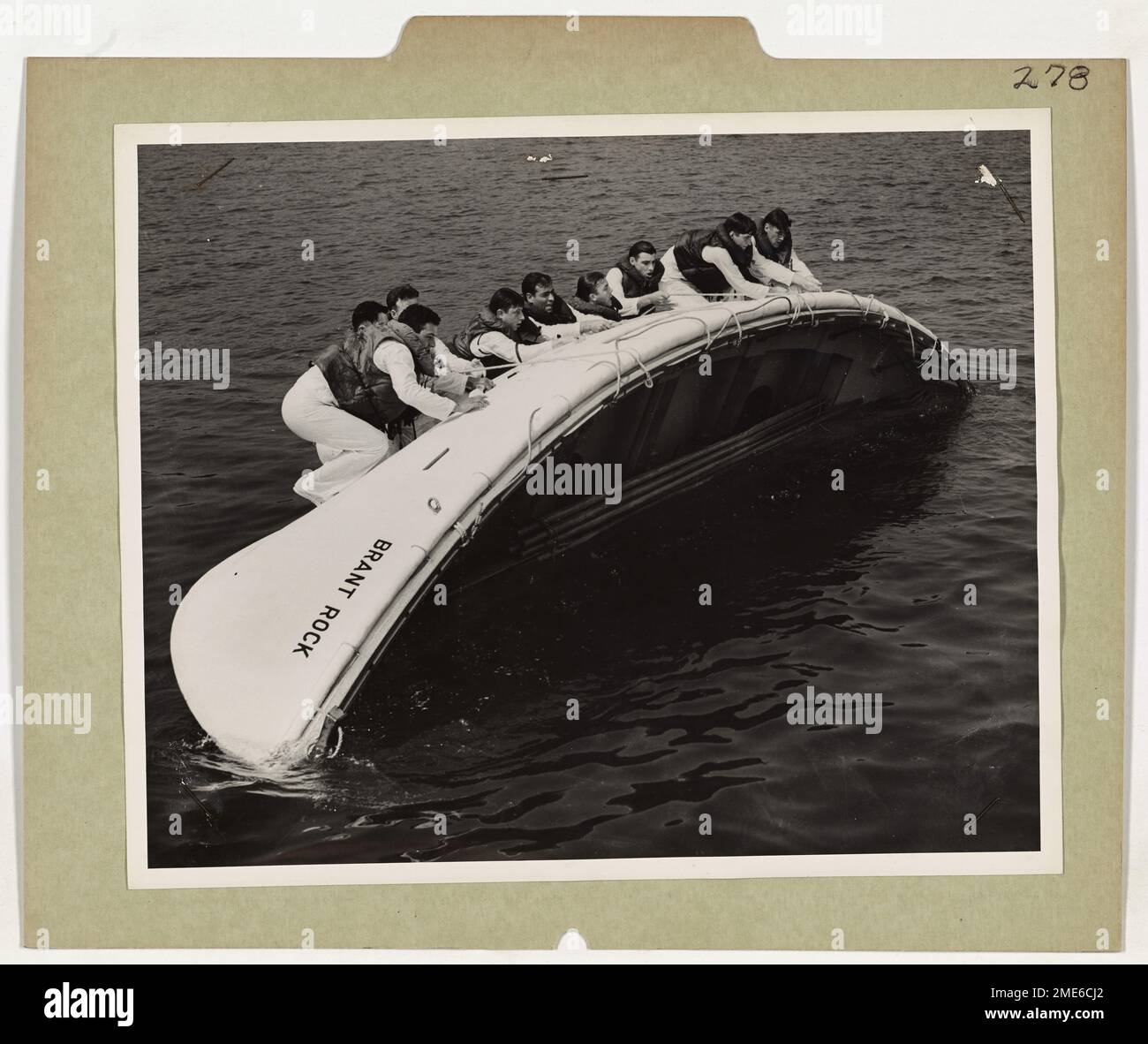 This image shows Coast Guardsmen flipping a lifeboat, marked 'Brant ...