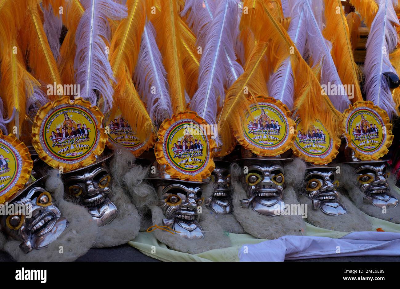 La Morenada dance masks sit on a sidewalk before the start of a parade ...