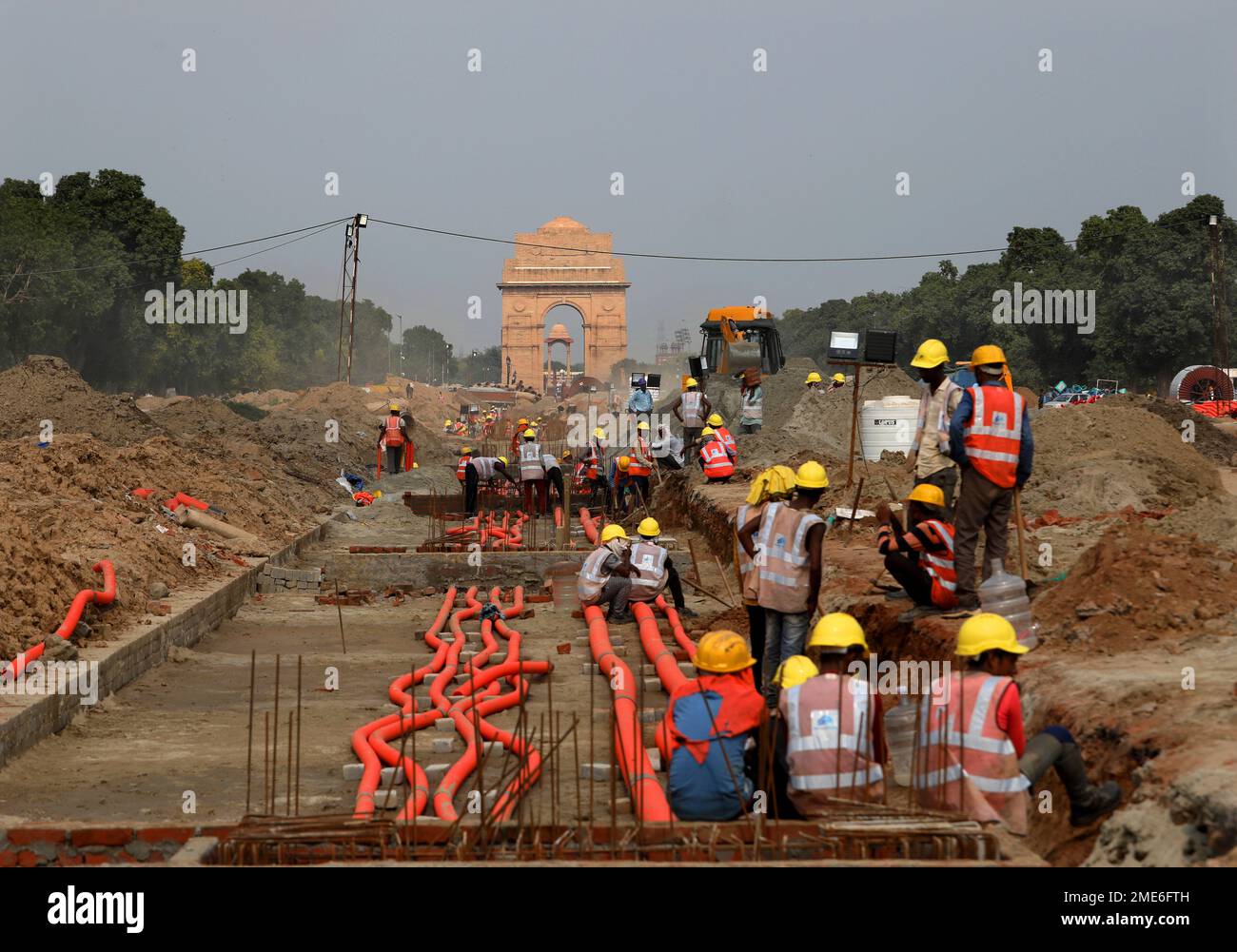 The landmark India Gate monument stand behind construction workers ...