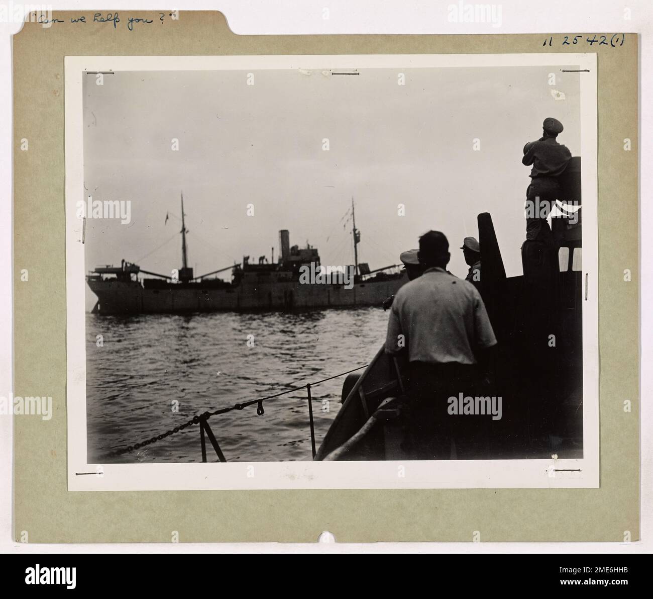 The photograph shows a Coast Guard cutter on convoy duty approaching a ...