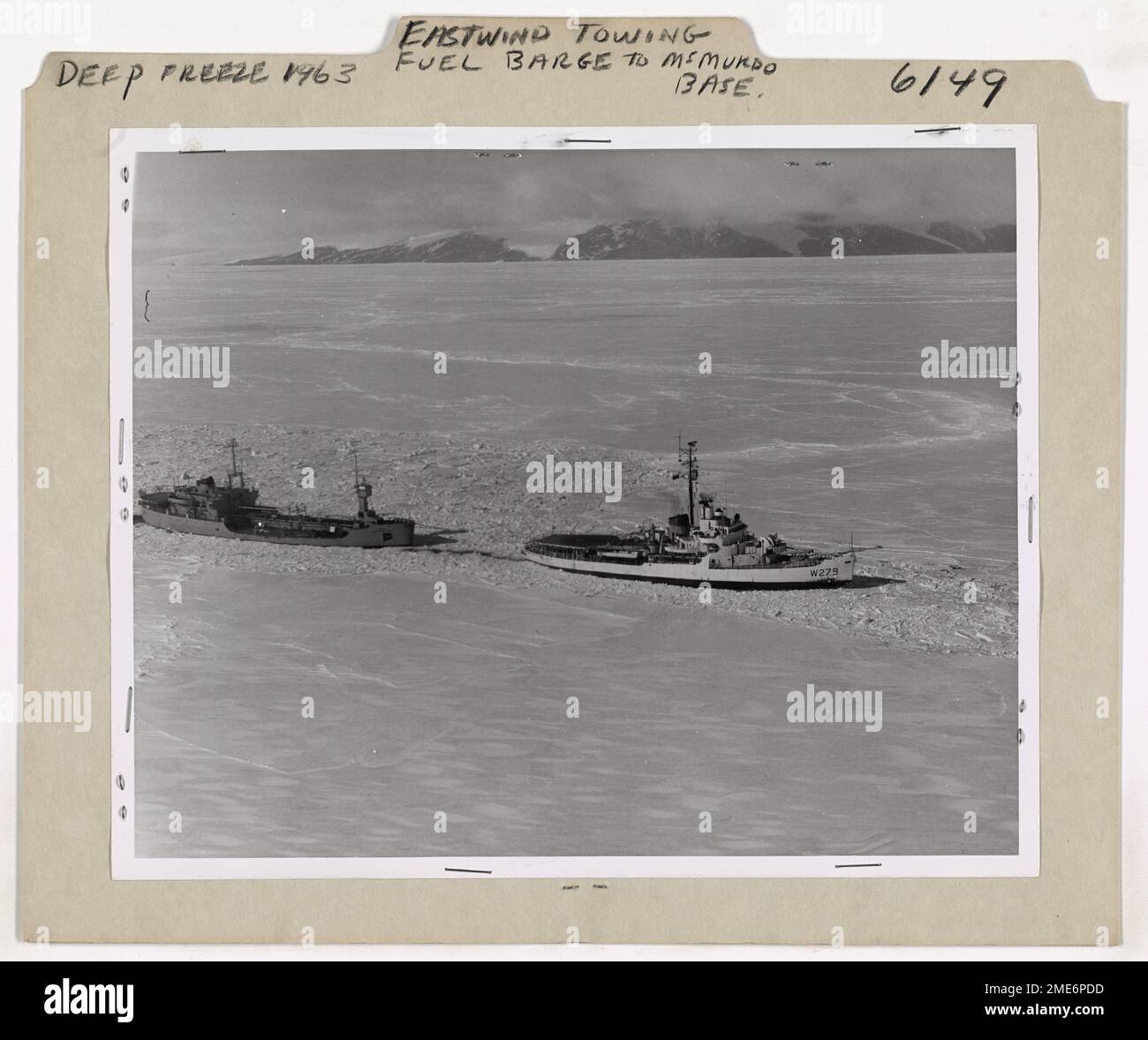 The U.S. Coast Guard icebreaker Eastwind tows a Navy fuel barge through ...