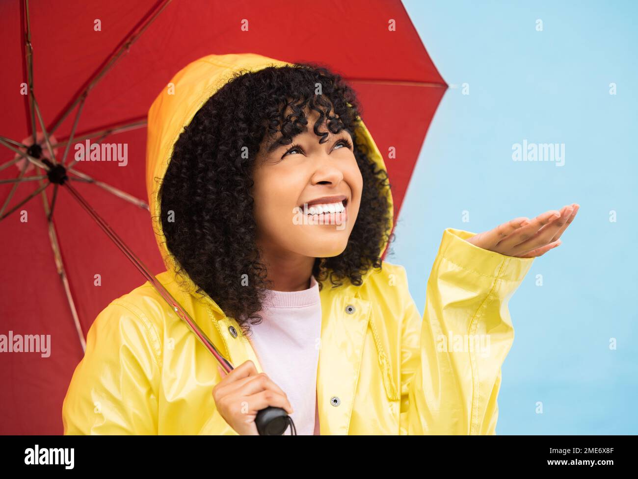 Black woman, umbrella or hand catching rain on isolated blue background ...