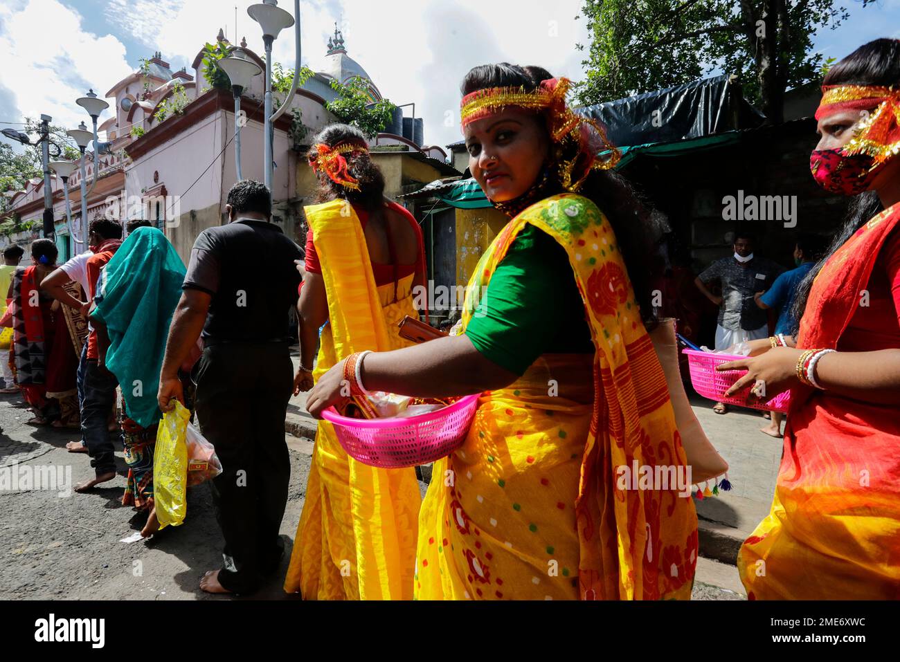 Hindu devotees stand in queue to offer prayers outside a temple during ...