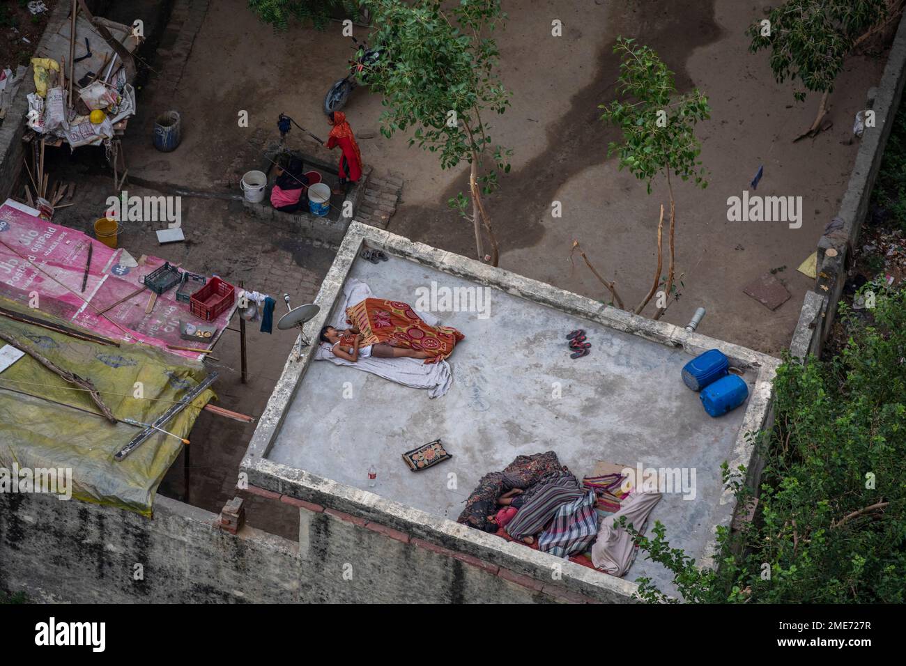 An Indian family sleeps on a rooftop at Itada village in Noida, a ...