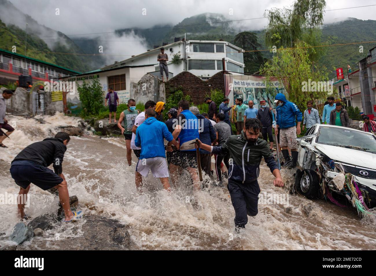 People place rocks to divert sudden gush of water during flash floods ...