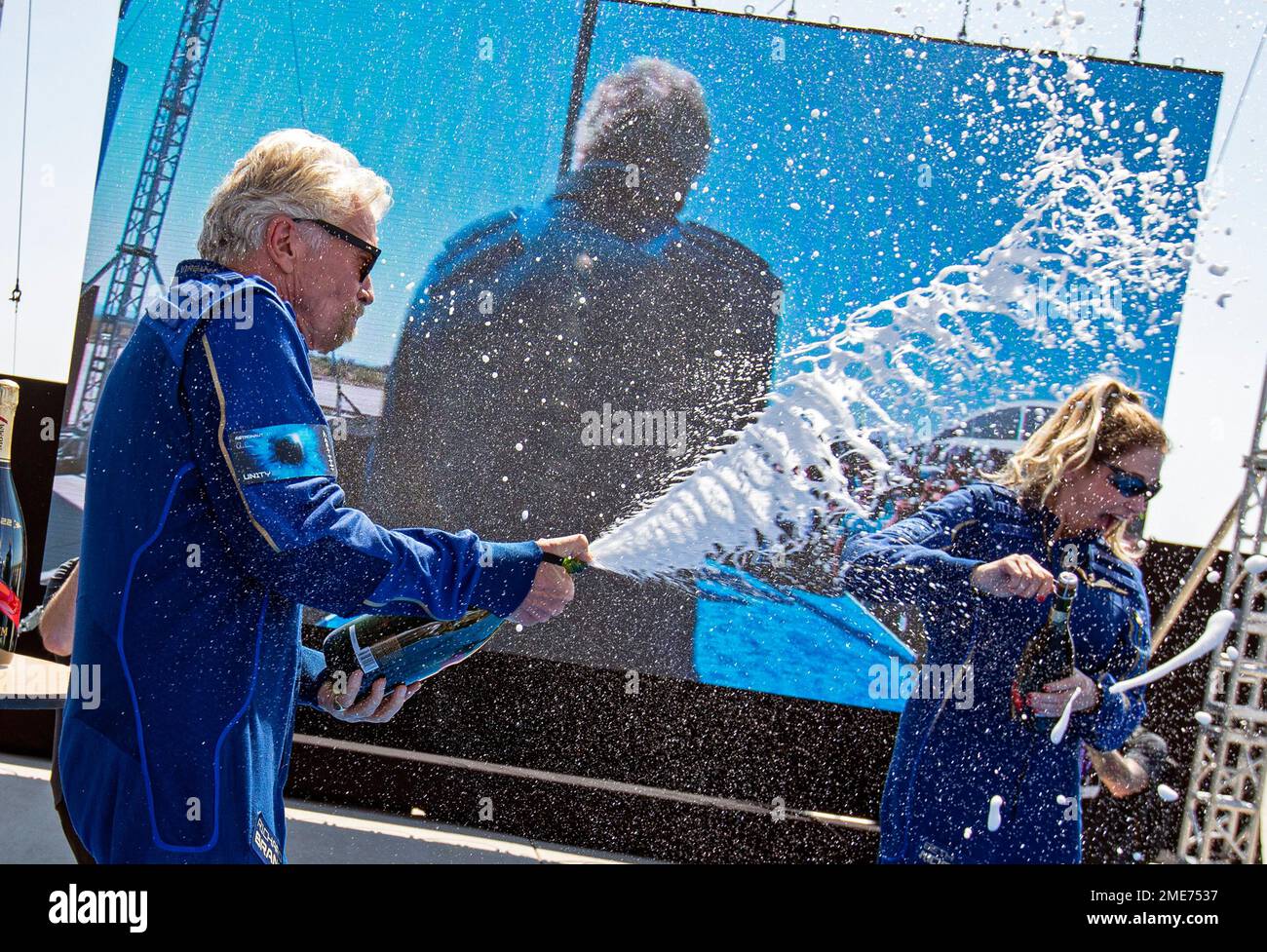 Virgin Galactic founder Richard Branson, left, sprays champagne to crew ...