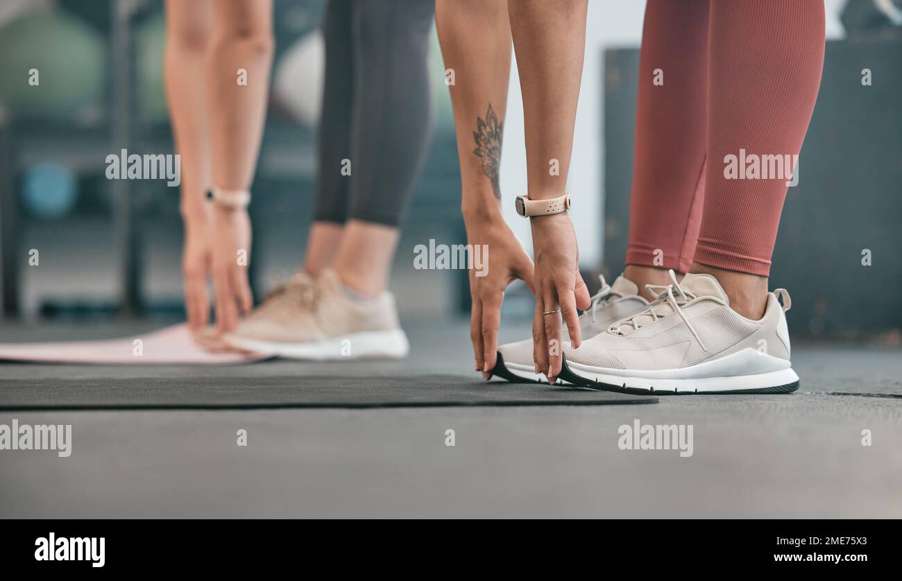 Fitness, hands or women stretching legs at gym to warm up body or relax ...