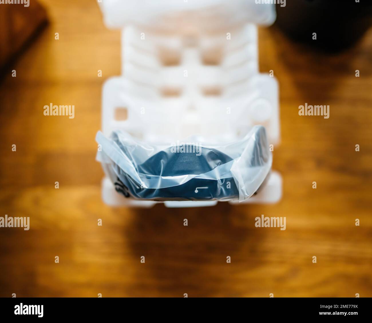 View from above of new lens hood in the plastic package during unboxing ...