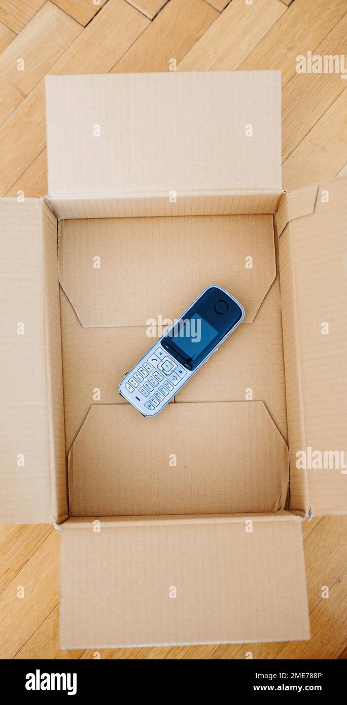Open cardboard parcel box package with cordless home office dect phone ...