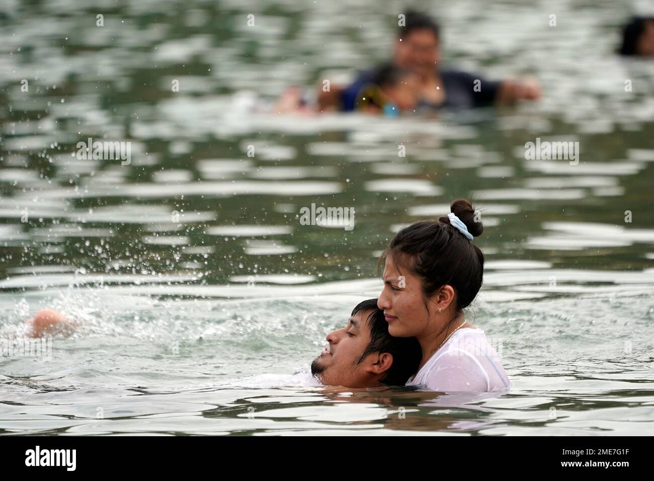 Visitors embrace while cooling off as temperatures rise at Castaic Lake ...