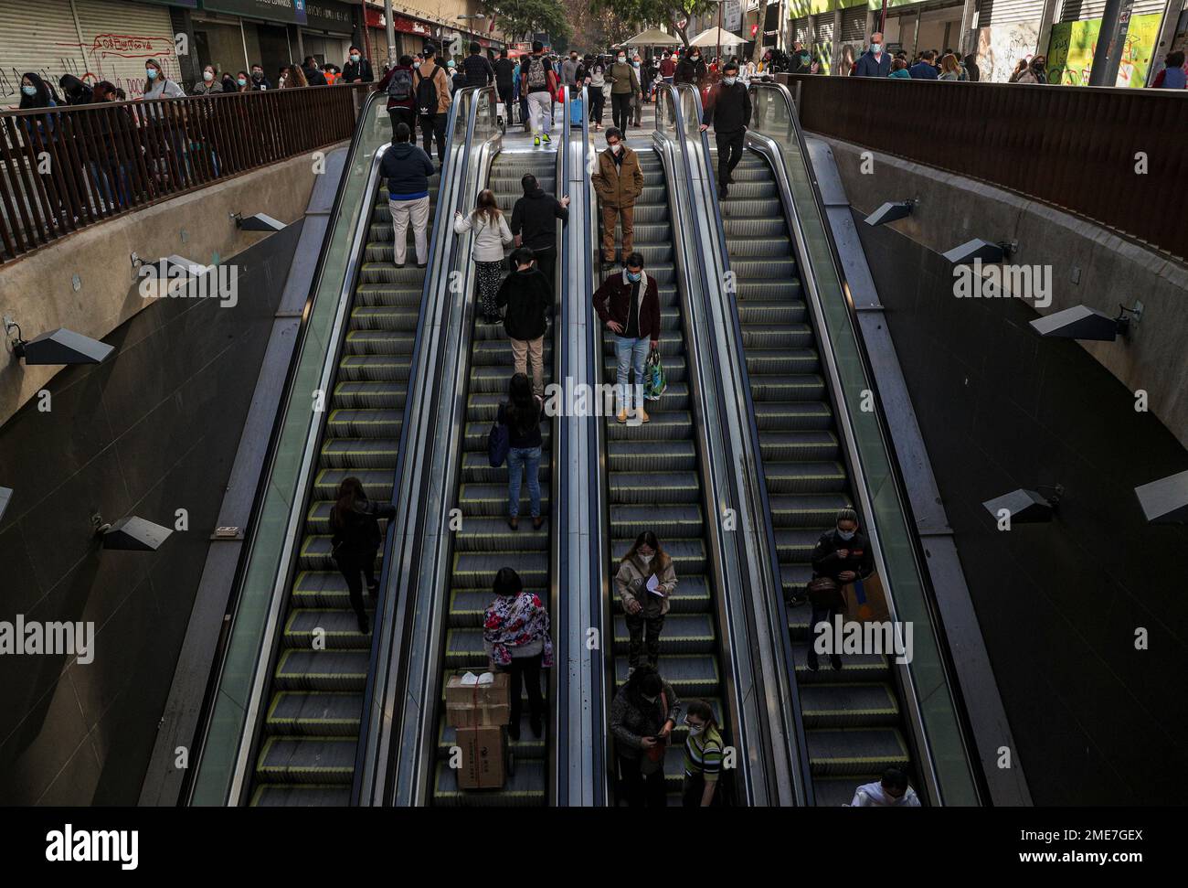 People ride an escalator down to the subway mid the new coronavirus ...