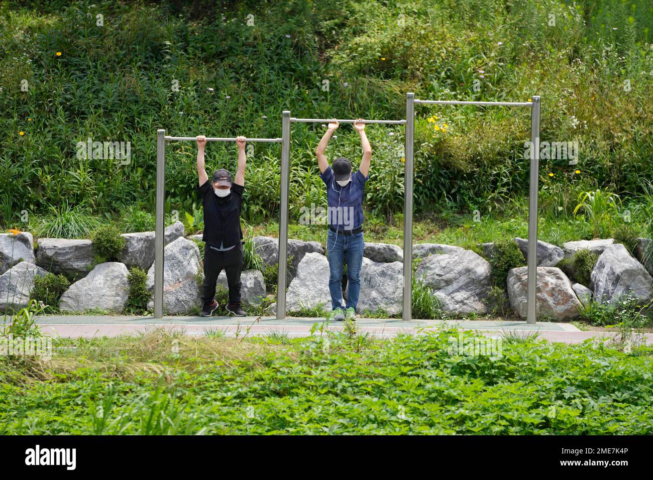 Visitors wearing face masks exercise during a lunch break at a park in ...