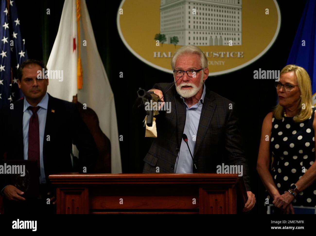 Rex Parris, City of Lancaster Mayor, at the podium, lifts a firearm at ...