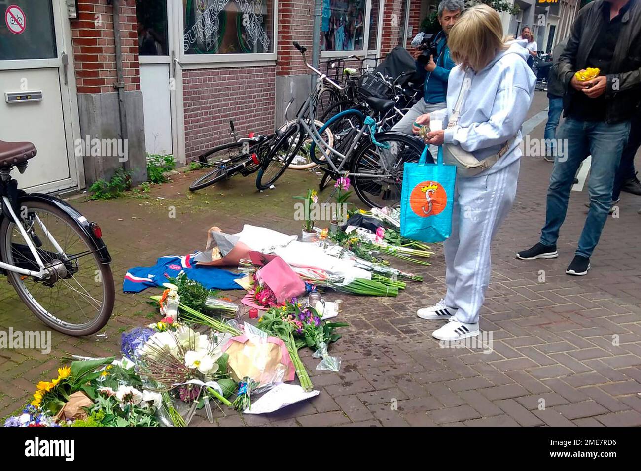 A woman stops by flowers laid where journalist Peter R. de Vries has ...