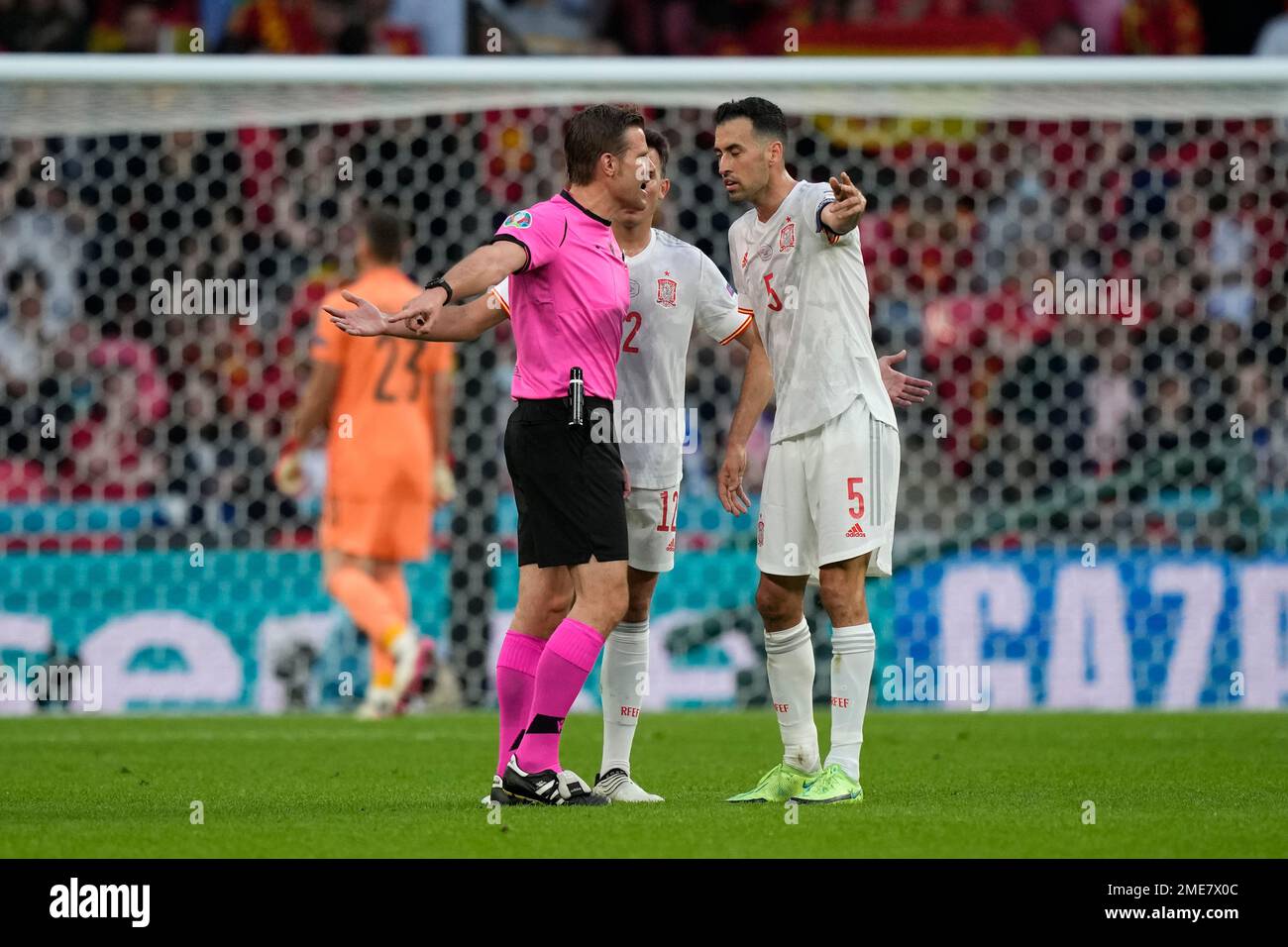 =Spain's Sergio Busquets, right, speaks with German referee Felix Brych ...