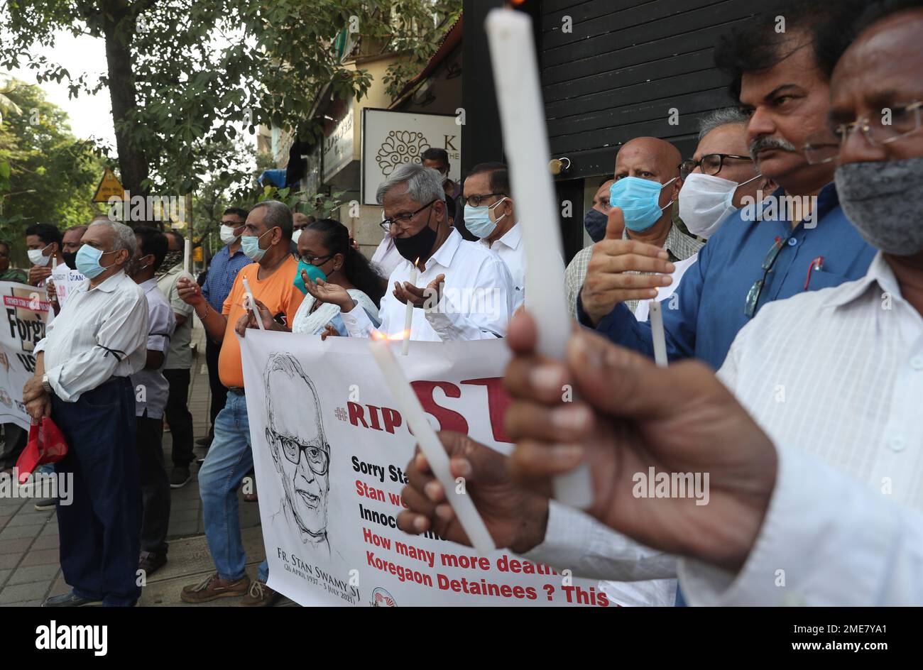 People hold candles during a prayer meeting for Father Stan Swamy ...