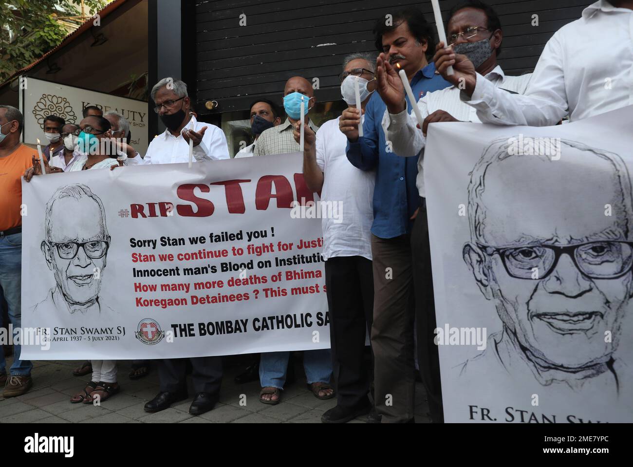 People hold banners and candles during a prayer meeting for Father Stan ...