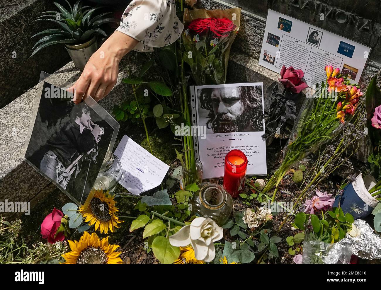 A woman place a photograph of late rock singer Jim Morrison on his tomb ...