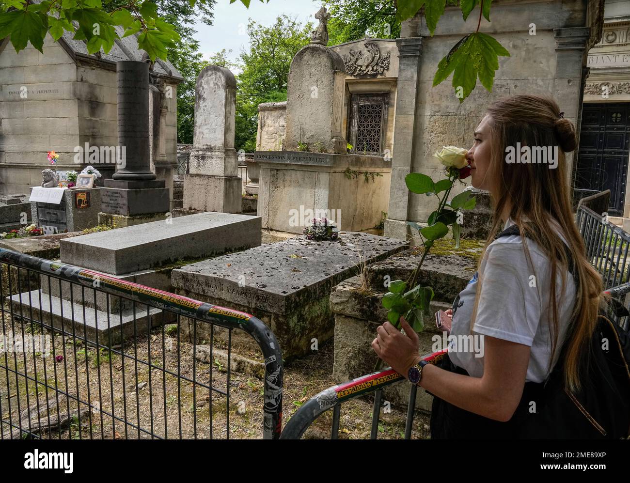 A woman holding flowers as she gather at eh tomb of rock singer Jim ...