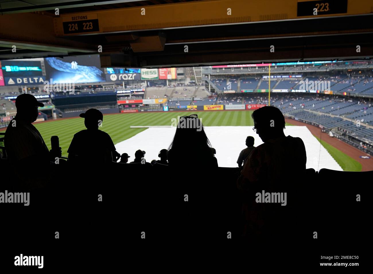 Fans wait for the rain to stop before a baseball game between the New ...