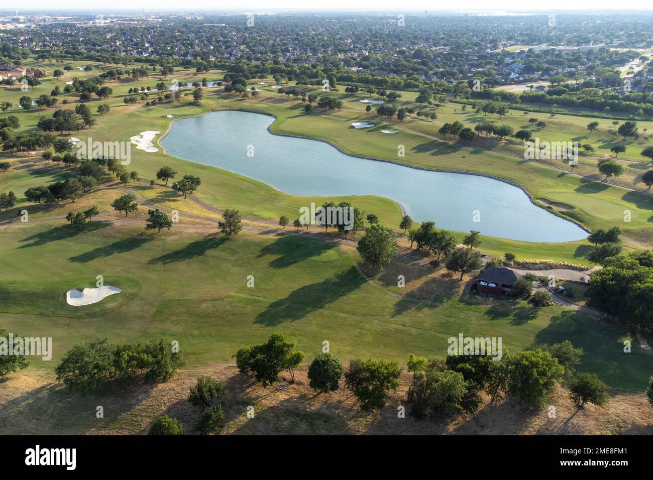 Aerial top view of a green park on the coast of lake. The water in the lake air shooting from ...