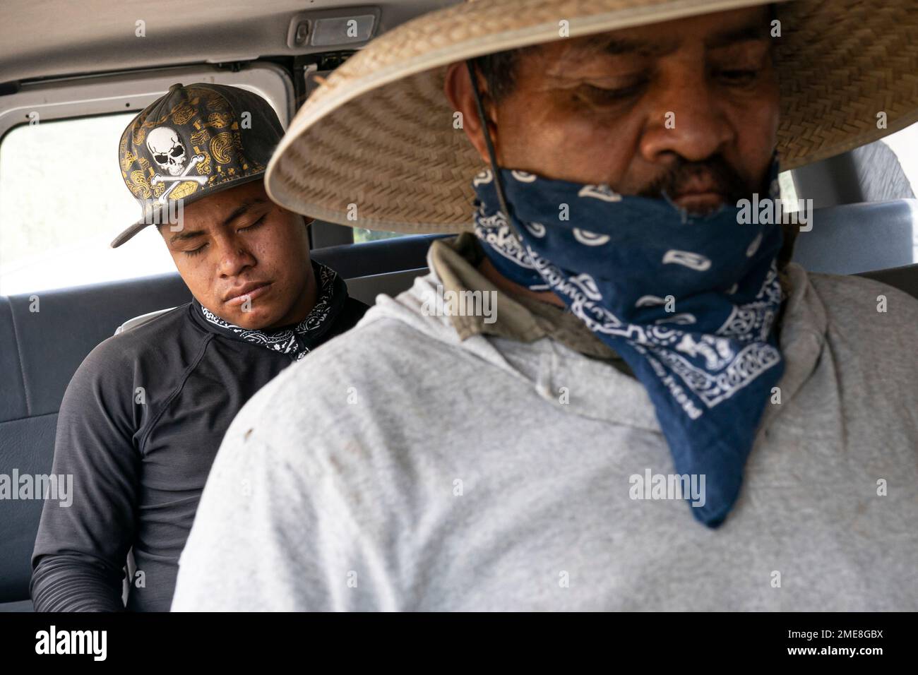 Two farmworkers, who declined to give their names, rest after a day ...