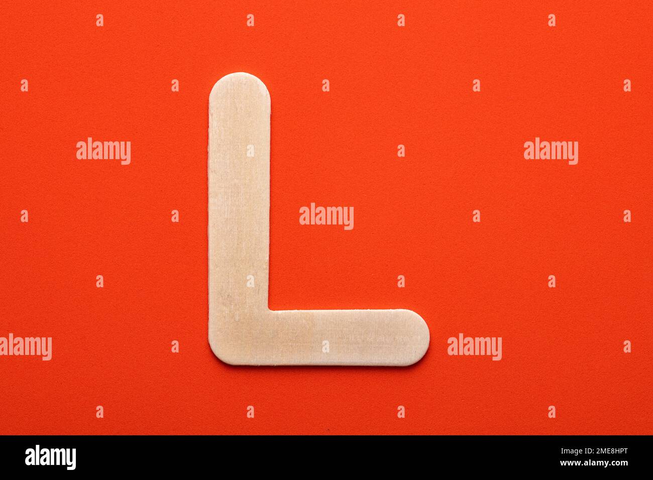 White wooden capital letter L on orange foamy background Stock Photo ...