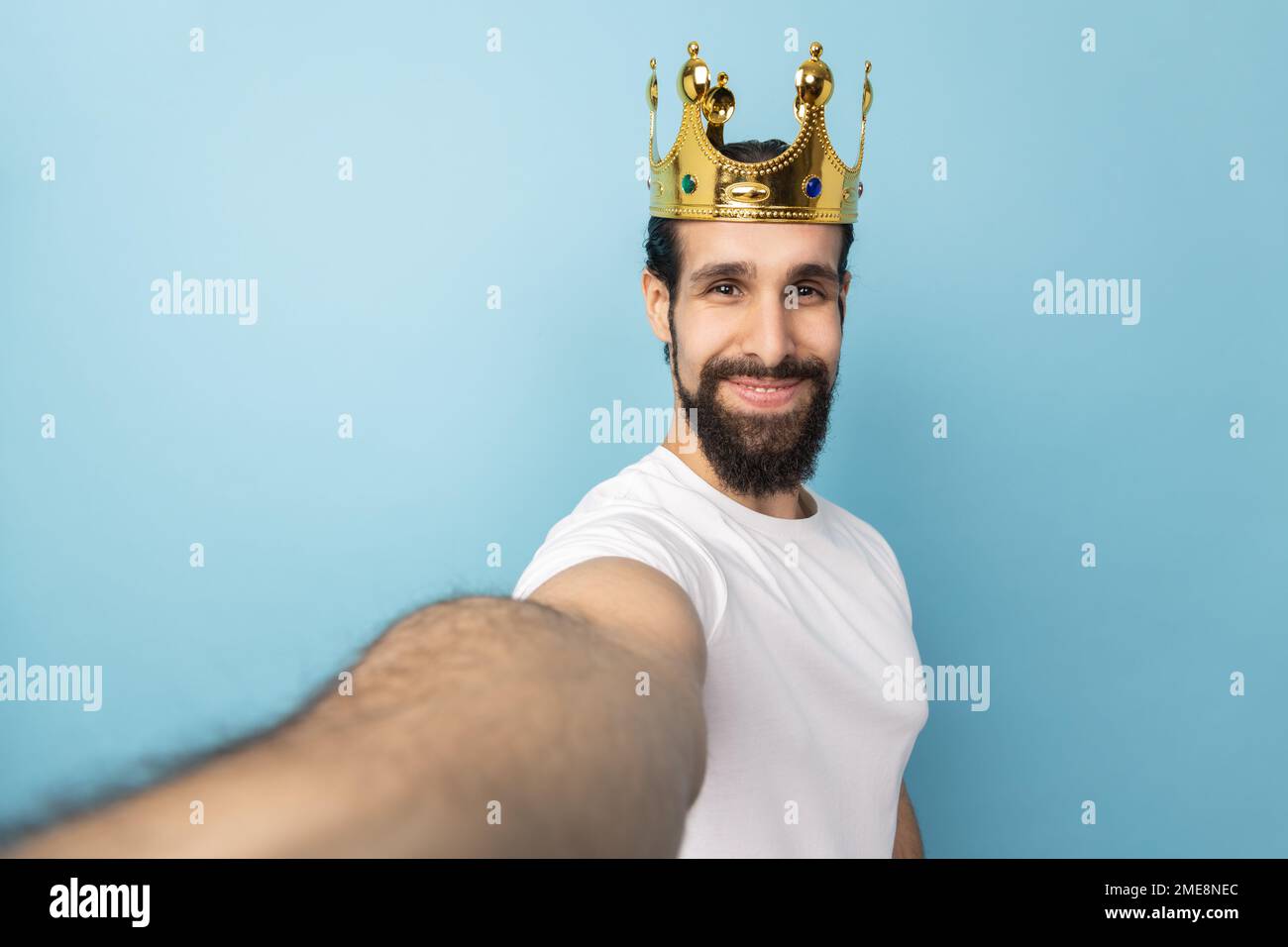 Portrait of satisfied handsome man with beard wearing white T-shirt and ...
