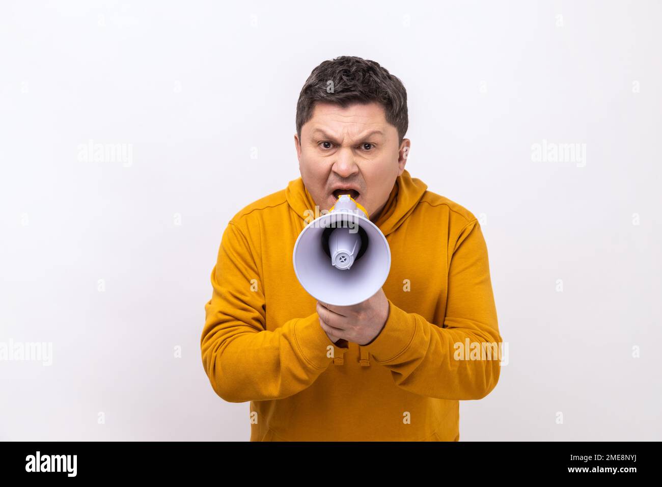 Portrait of dark haired middle aged handsome man screaming in megaphone ...