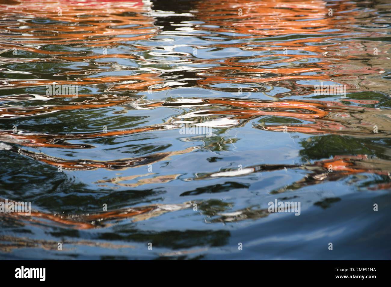 Reflections of colors on the surface of the water of a river, an orange ...