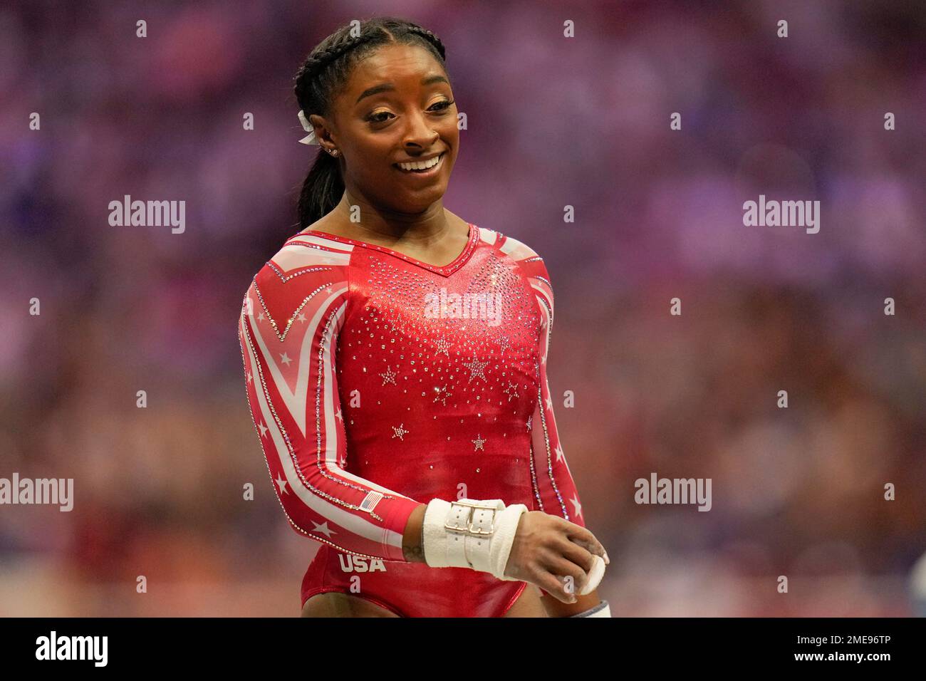 Simone Biles smiles after competing on the uneven bars during the women ...