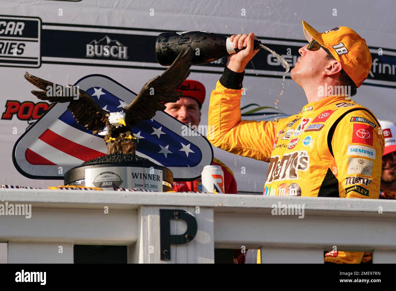 Kyle Busch celebrates beside the trophy after winning a NASCAR Cup ...