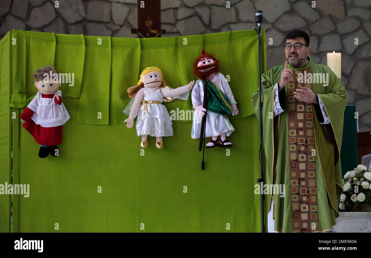Catholic Priest Carlos Cardona delivers his homily during Mass, next to ...