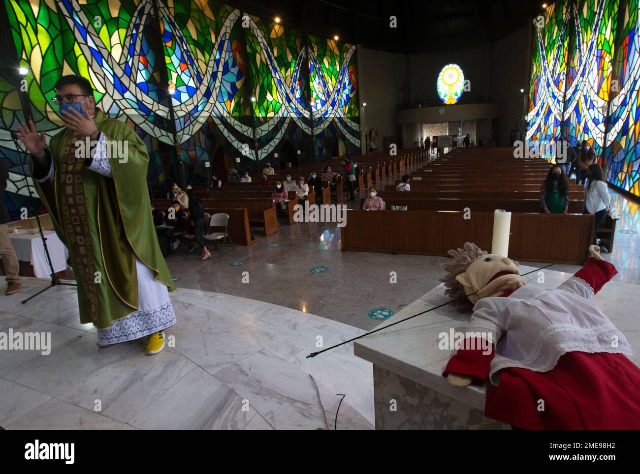 Catholic Priest Carlos Cardona officiates Mass next to his puppet Monsi ...