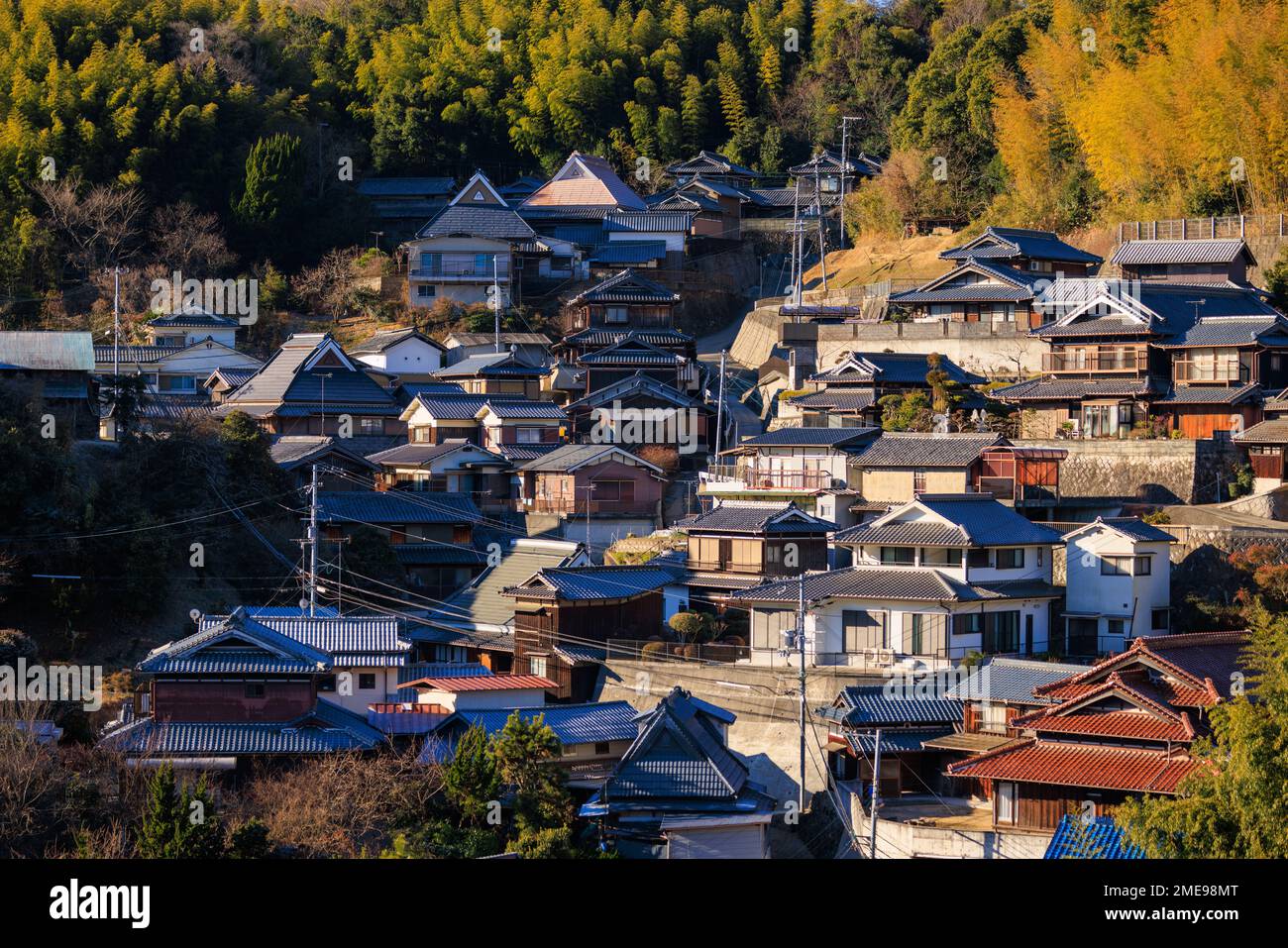 Japanese houses in small mountain village between trees on sunny day ...