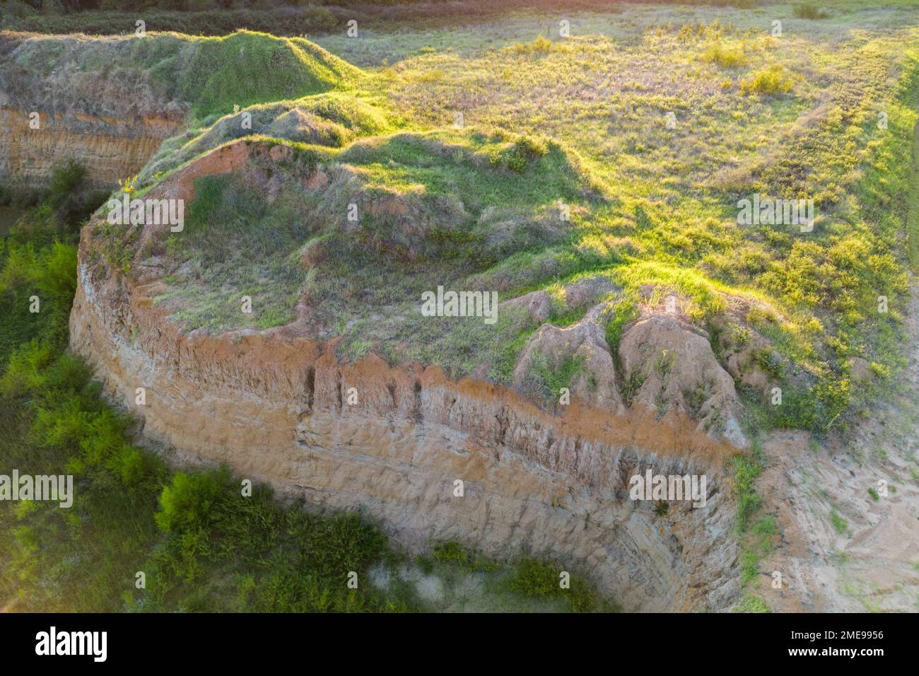 Aerial top view of sand quarry with green trees, slope of open pit ...