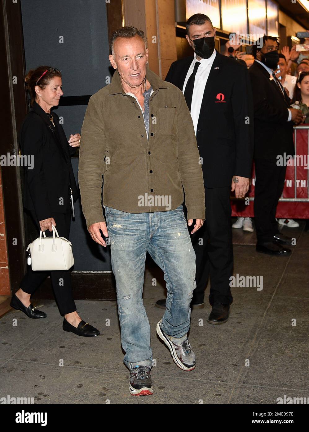 Singer-songwriter Bruce Springsteen exits out the stage door after the ...
