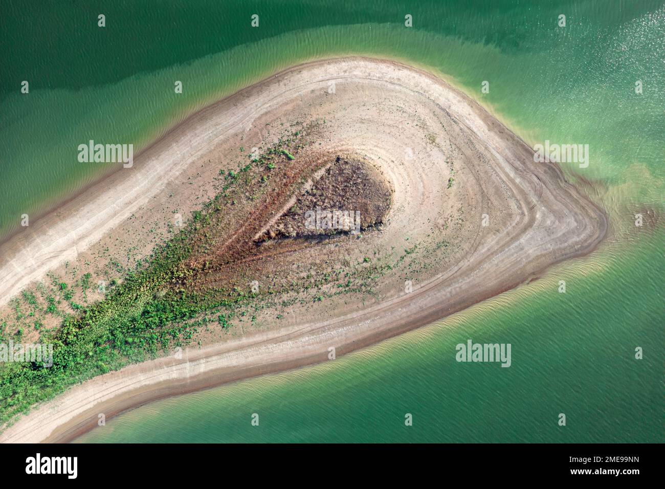 Aerial view of island with green plants surrounded by sea or ocean with ...