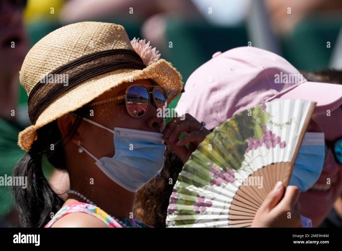 A spectator uses a fan to cool off at the U.S. Olympic Track and Field ...