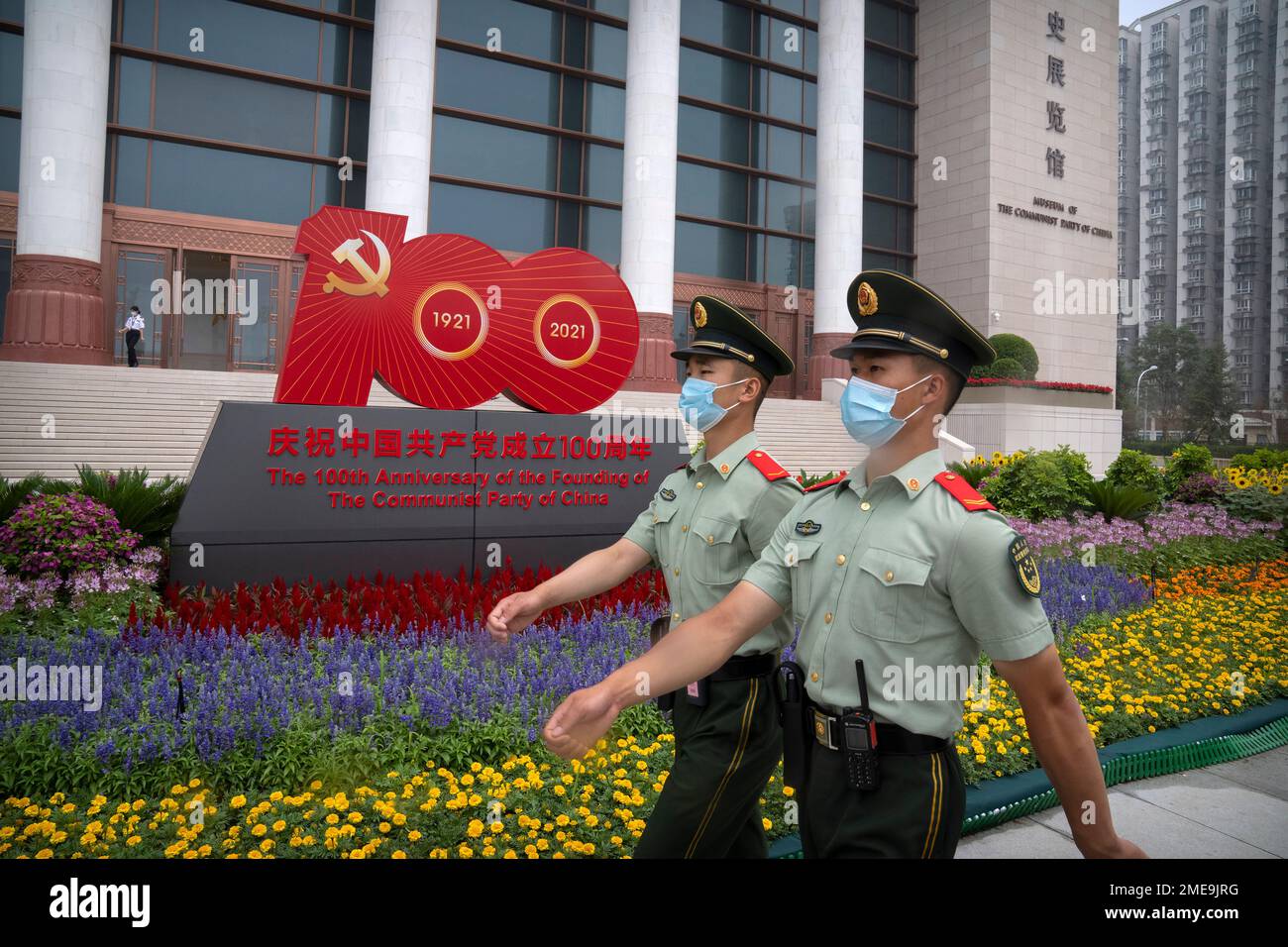 Chinese paramilitary police walk past a display commemorating the 100th ...
