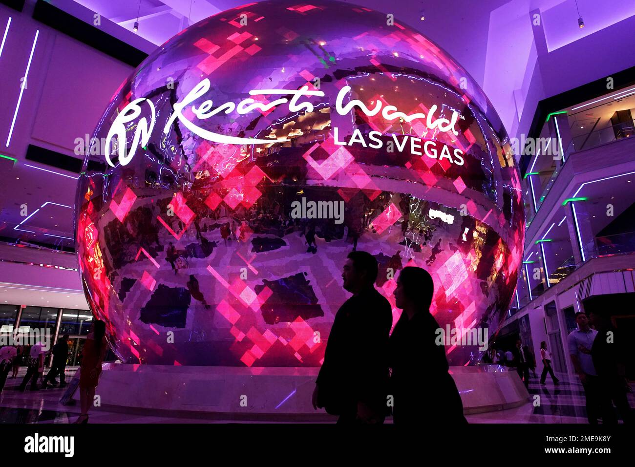 People walk by an illuminated sphere during the the opening night of ...