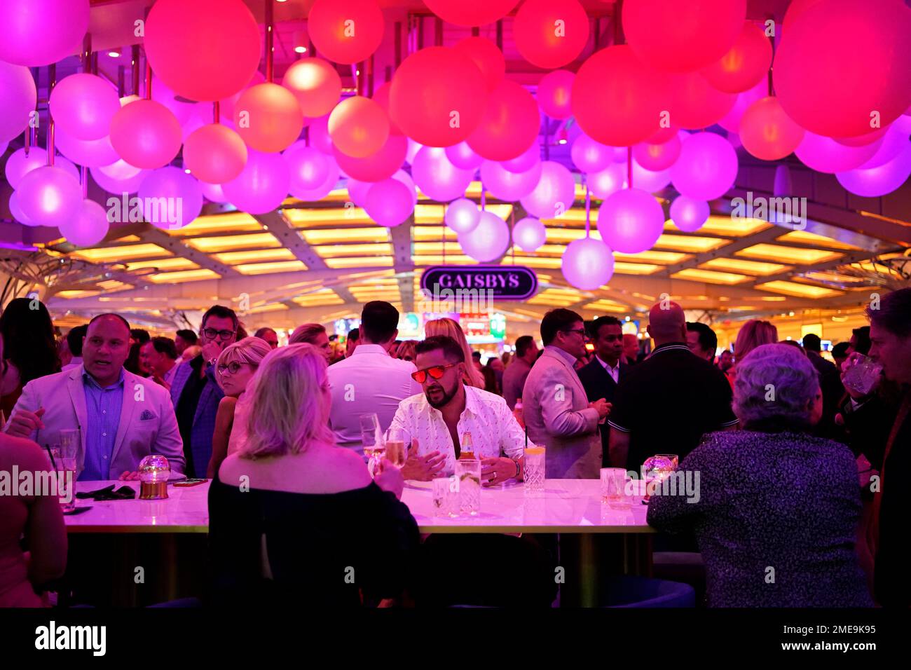 People walk by an illuminated sphere during the the opening night of ...