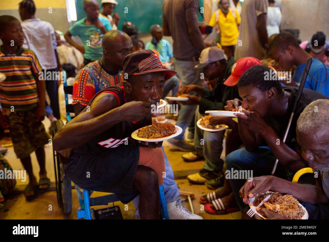A group of blind and disabled people eat at a refuge for displaced ...